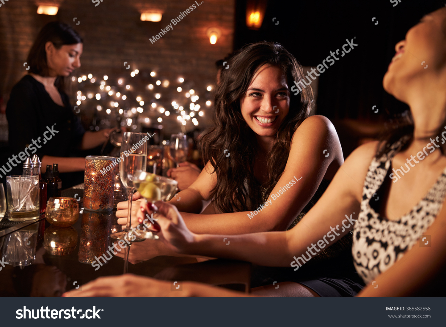 stock-photo-female-friends-enjoying-night-out-at-cocktail-bar-365582558 ...